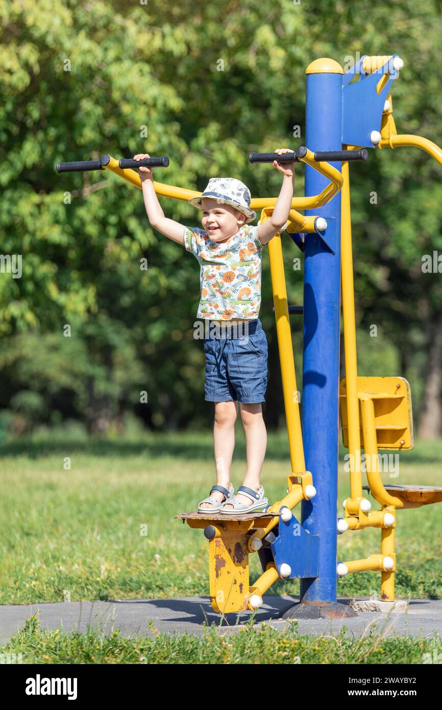 A cheerful child during a walk in the park, climbs on a large exercise ...
