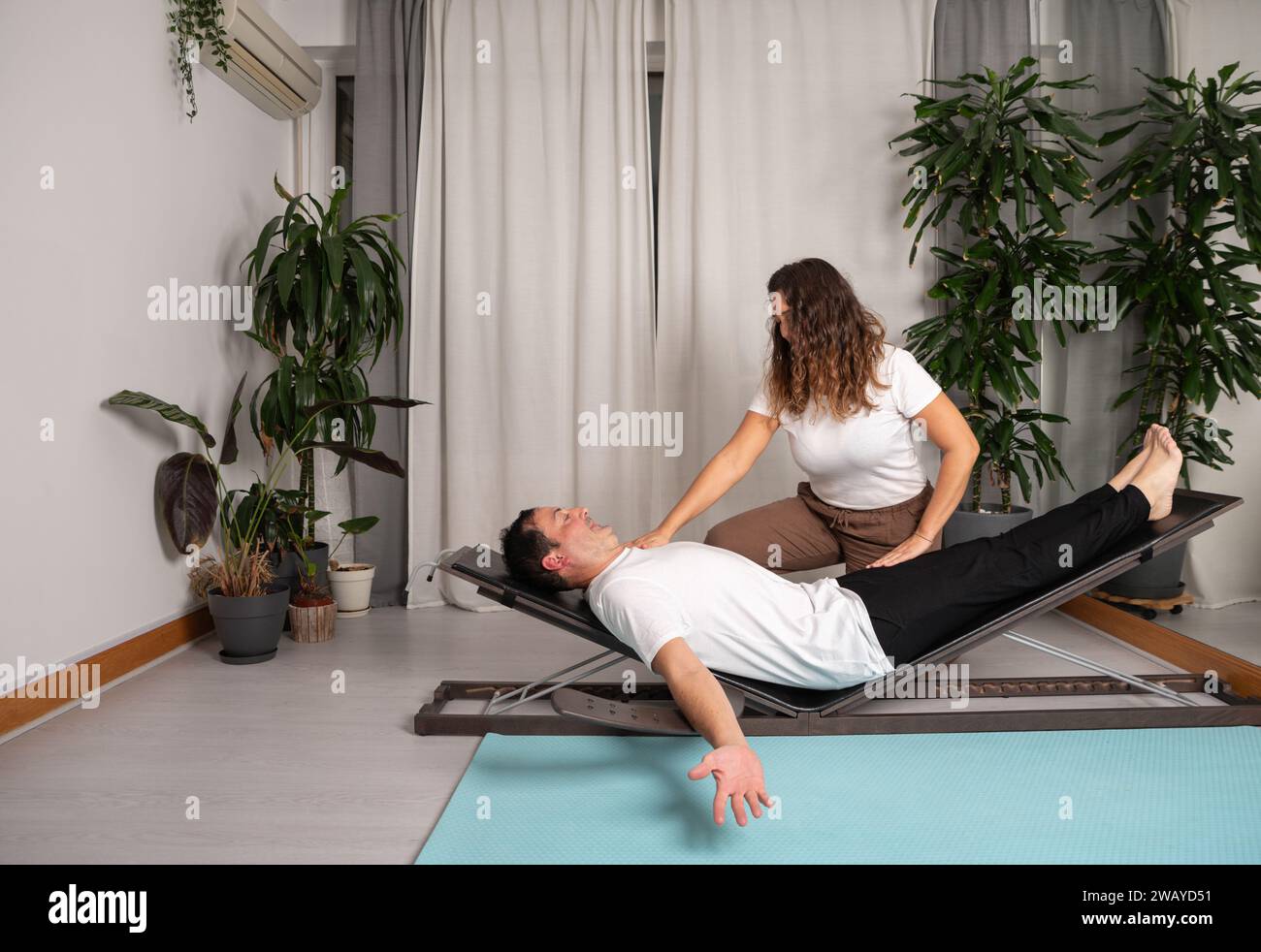 Relaxed man learning yoga poses with teacher Stock Photo - Alamy