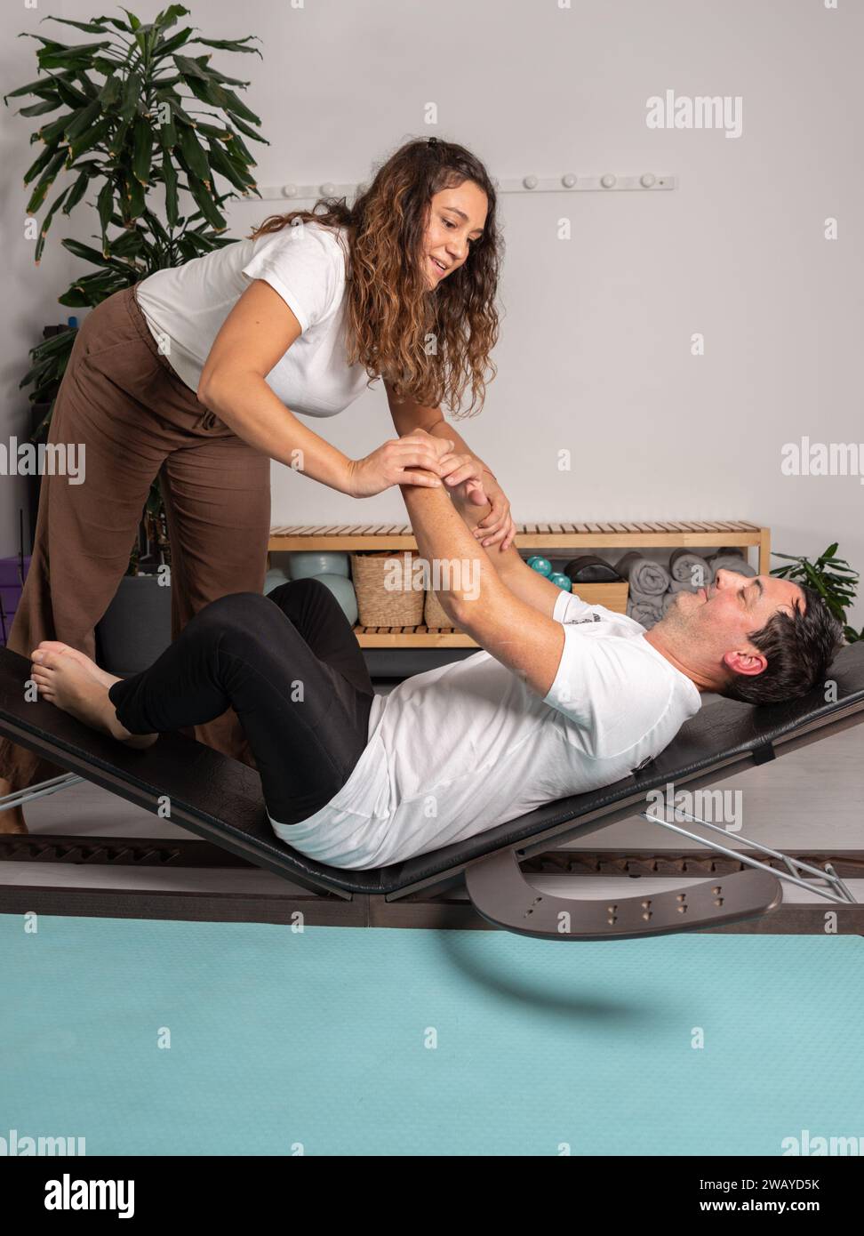 Relaxed man learning yoga poses with teacher Stock Photo - Alamy