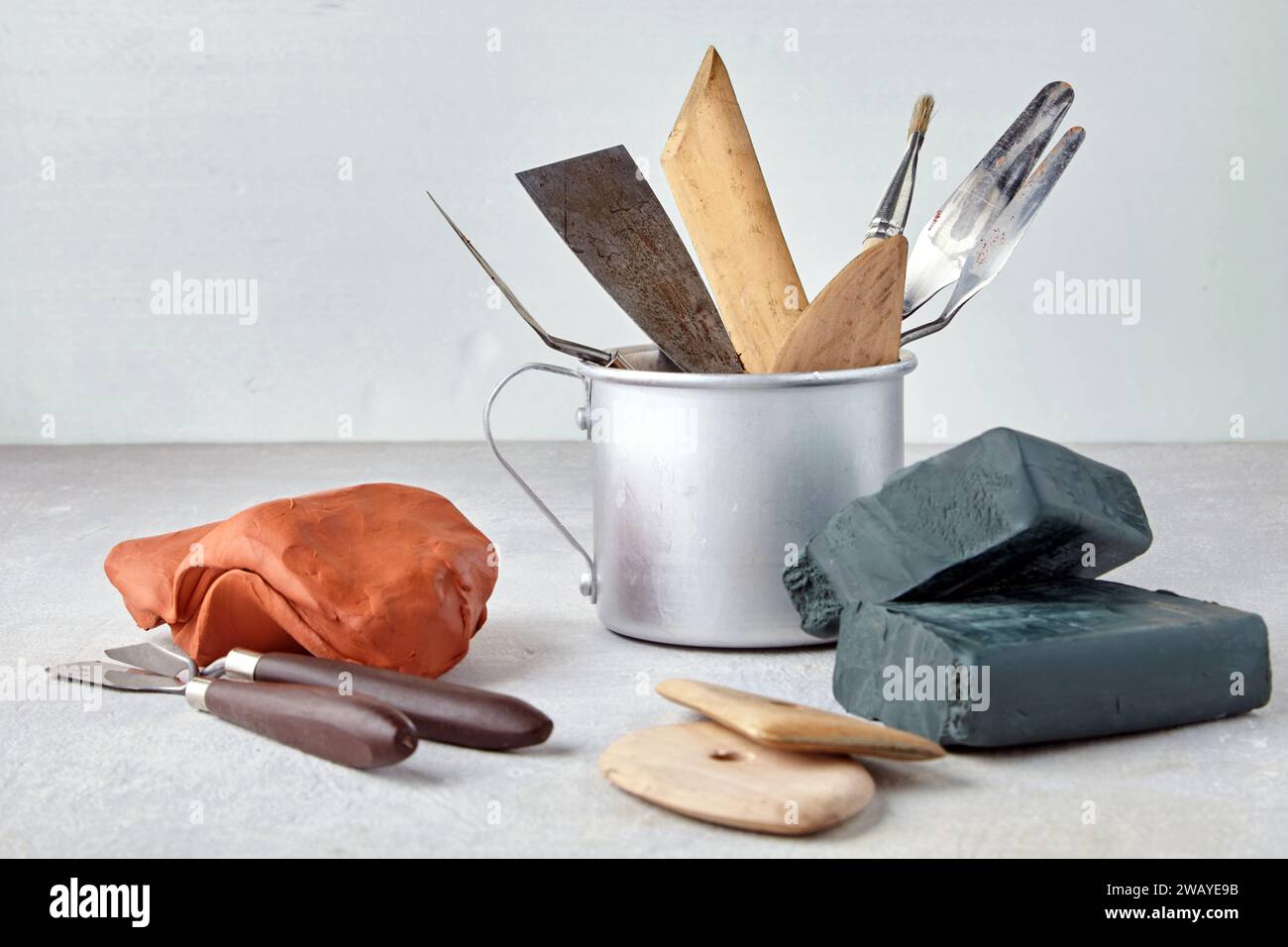 Many different tools and pieces of orange clay and green plasticine in ...