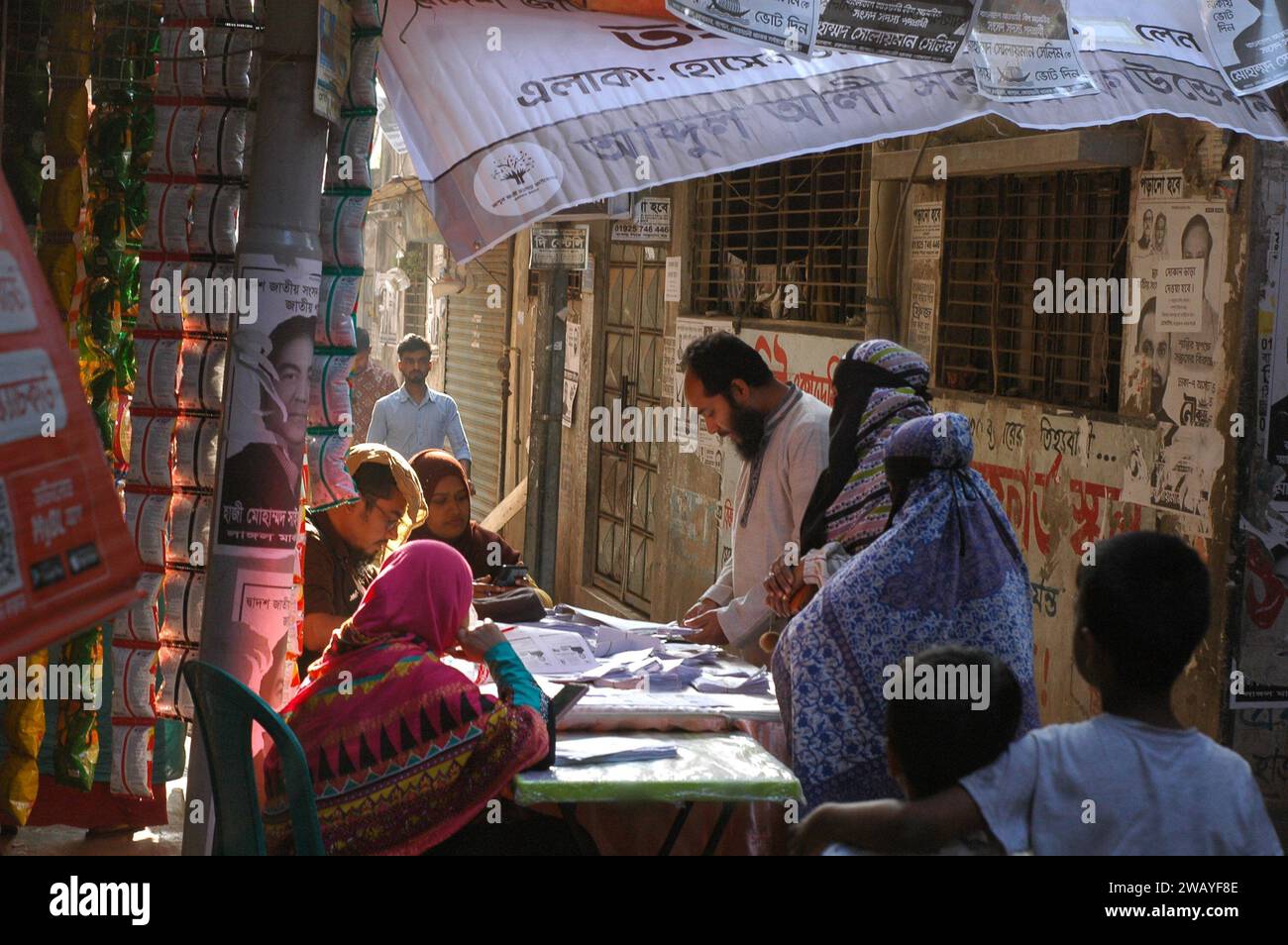 Dhaka, Bangladesh. 8th Jan, 2024. People gather in front of a booth to ...