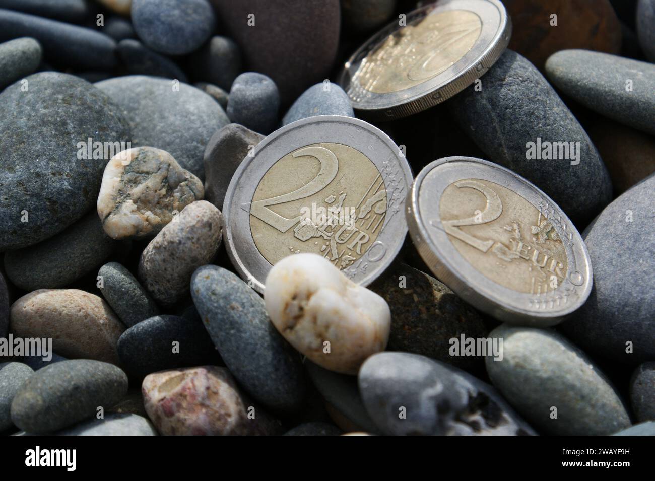 2 euro coins in pebbles. Three two euro coins Stock Photo - Alamy