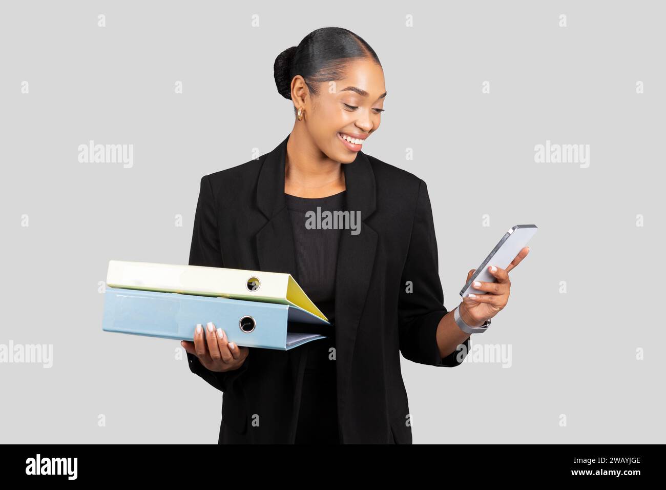 Smiling professional African American businesswoman multitasking with ...