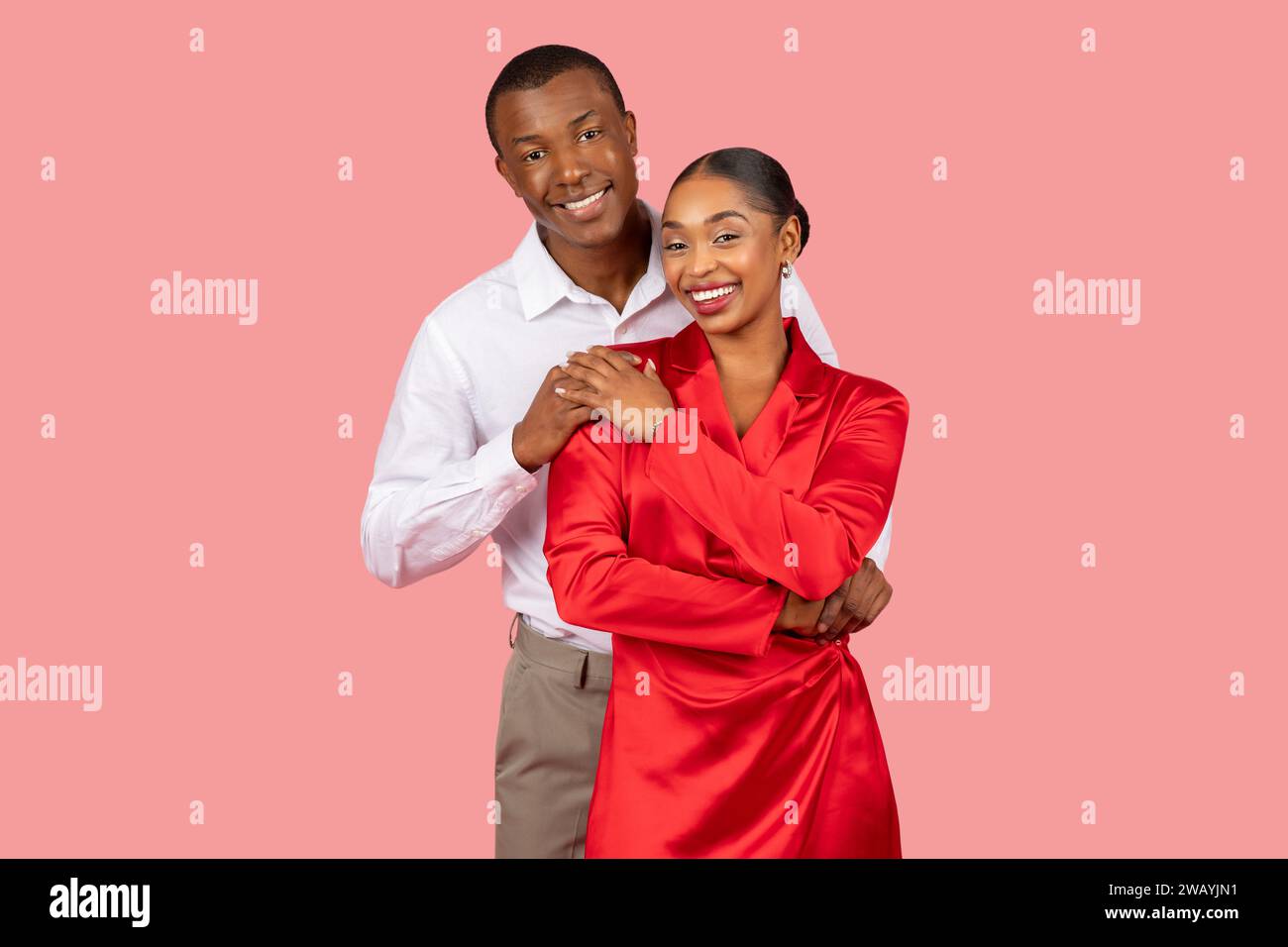 Happy black couple embracing and smiling on pink background Stock Photo ...