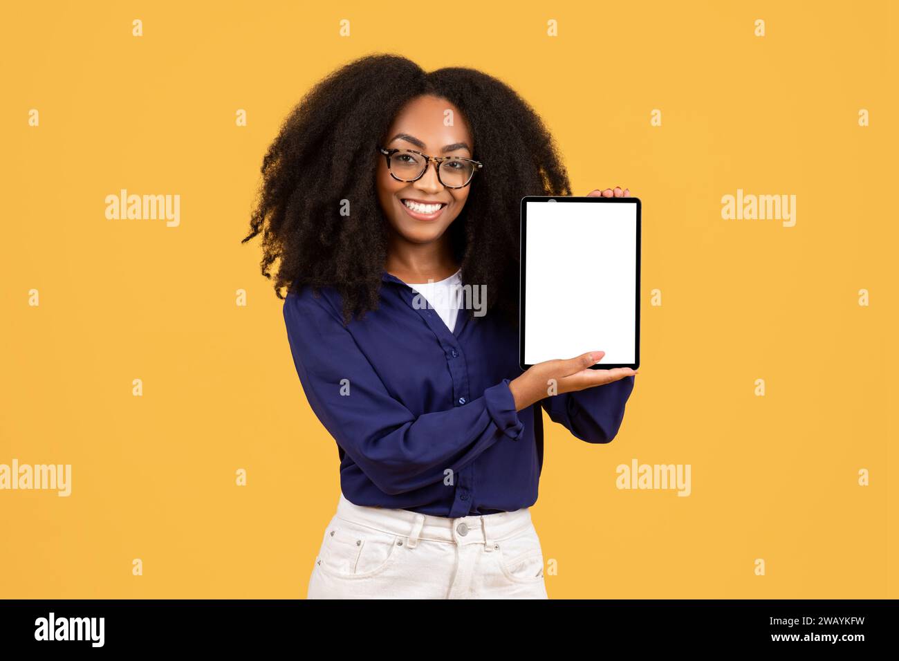 Happy black young student lady showing tablet with blank screen ...
