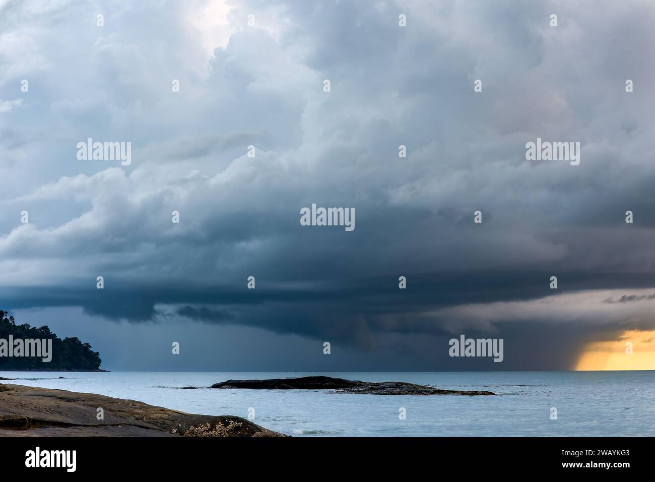 Huge offshore thunder storm and rain at sunset over a tropical ocean ...