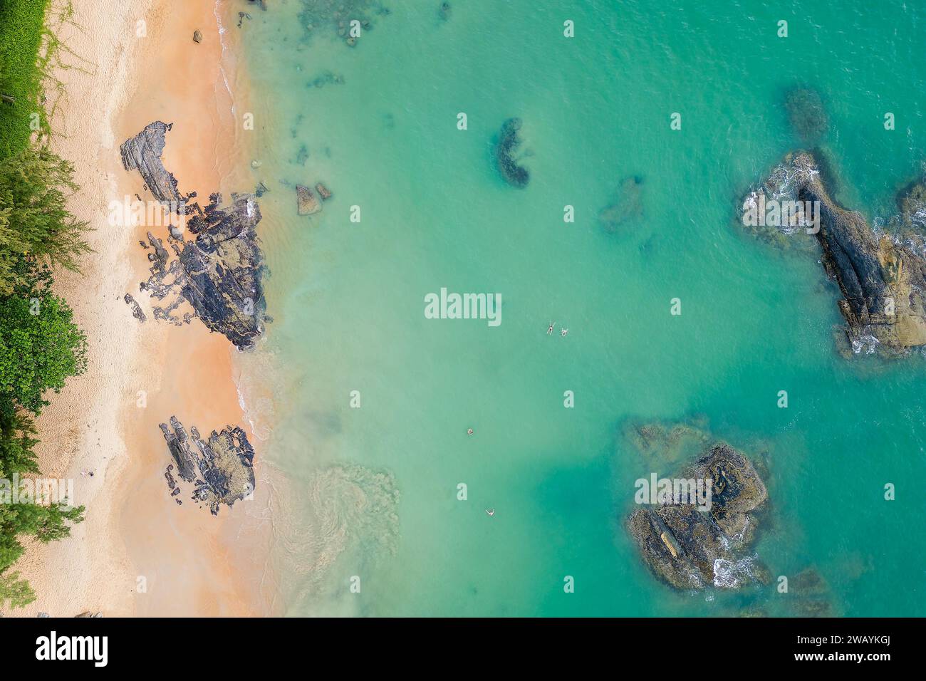 Overhead aerial view of a small, sandy tropical beach and shallow ocean ...