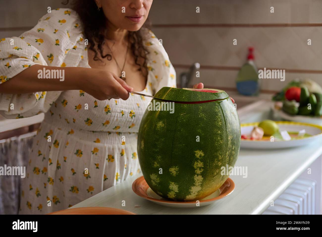 Details on watermelon and cropped view of a housewife in sundress ...