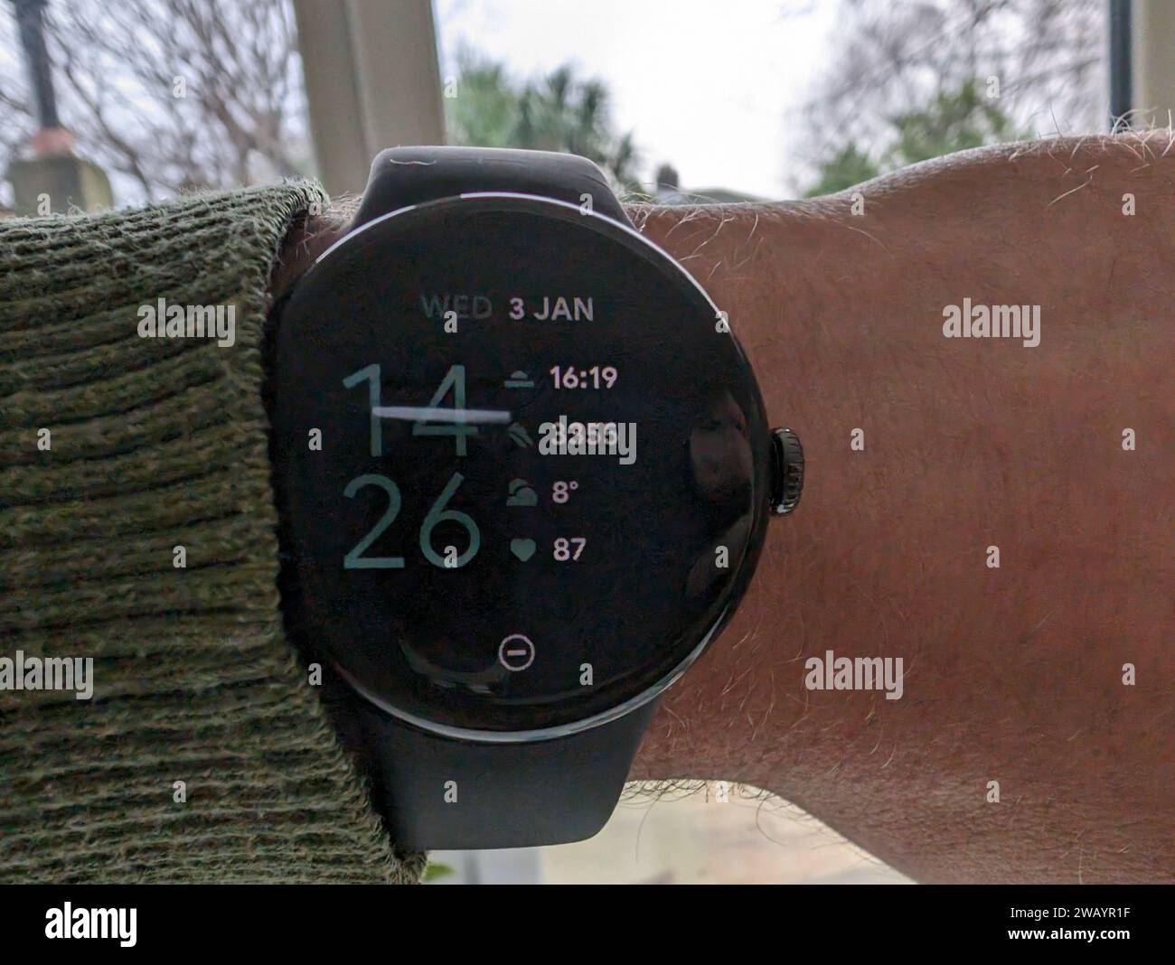 A Caucasian male stands with his wrist extended wearing a modern ...