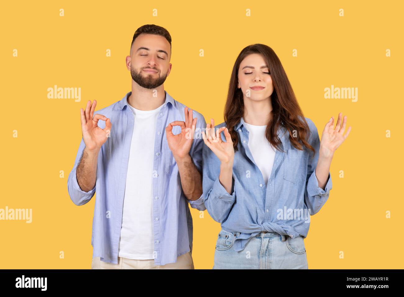 Cheerful european couple show ok gesture with hands, meditating with ...