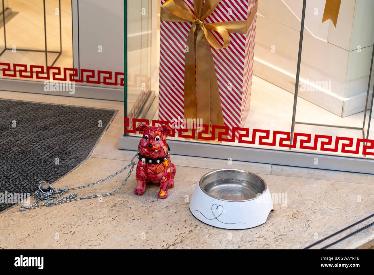 A red statue of a chained dog in front of a shop window in Budapest on ...
