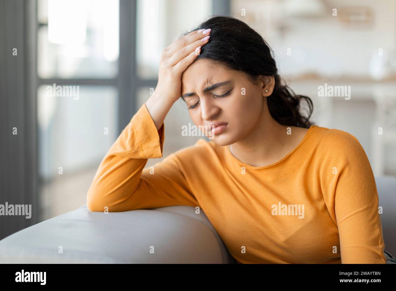 Depressed young indian woman suffering from headache, pressing her ...