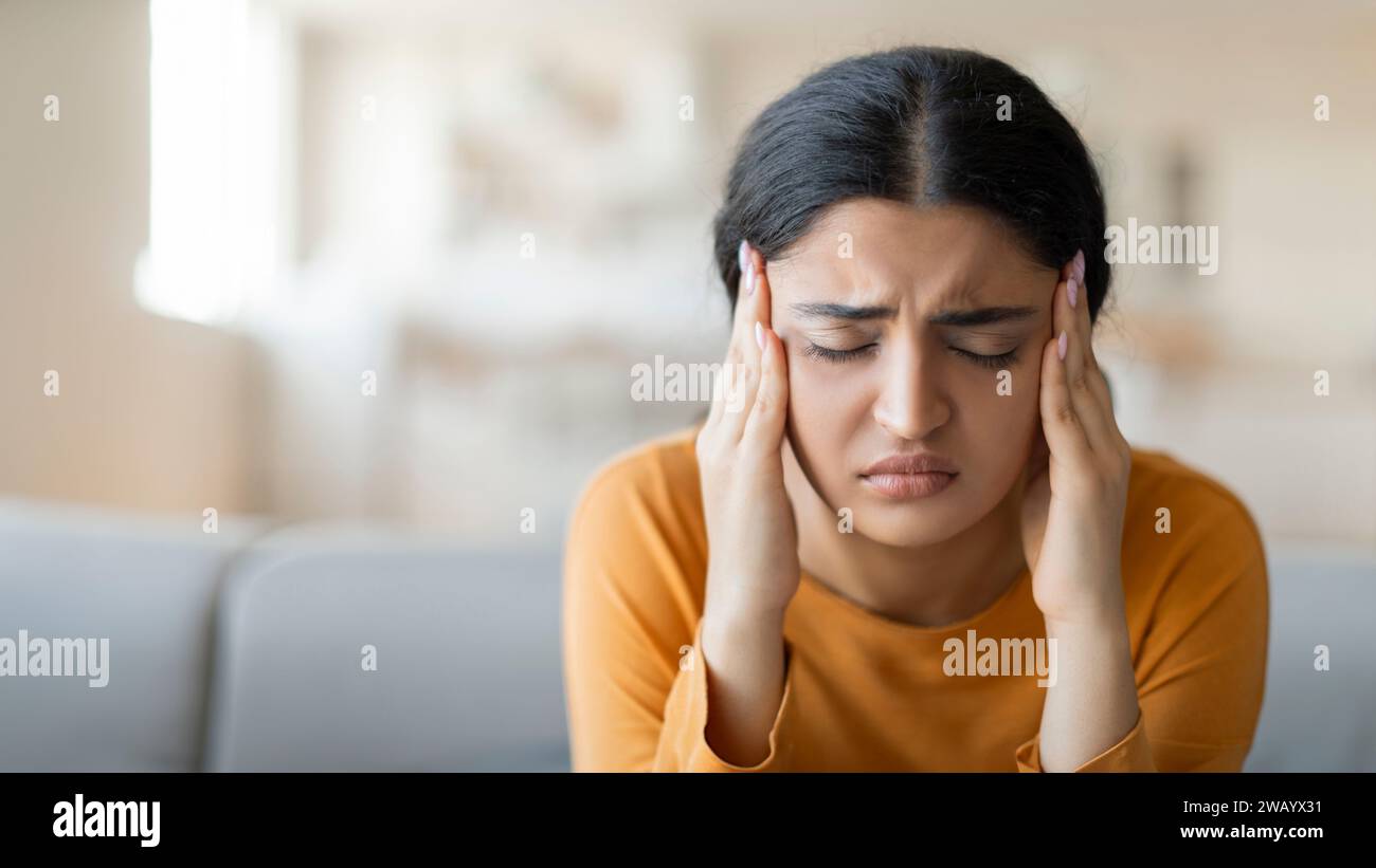 Stressed young indian woman suffering from severe headache or migraine ...