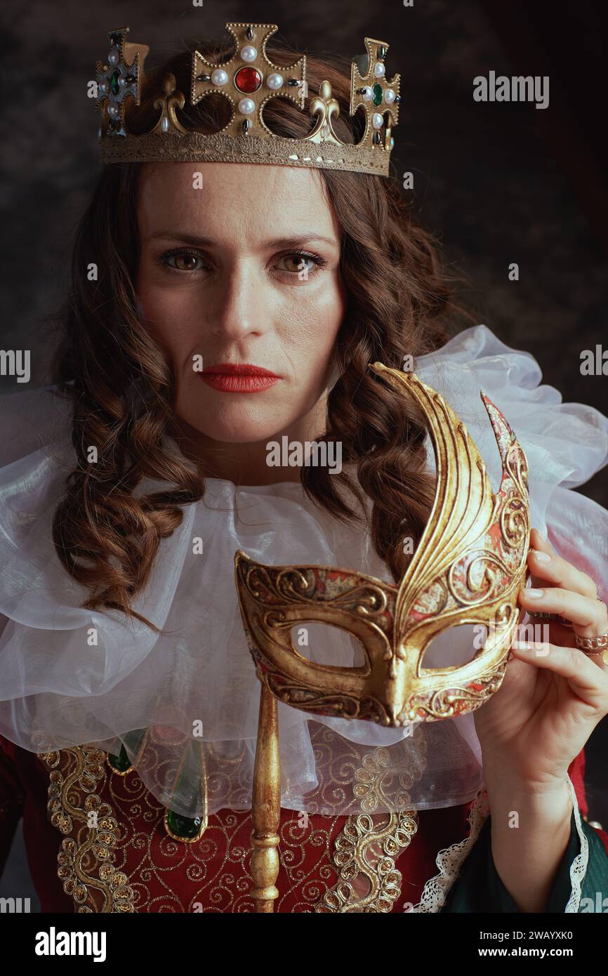medieval queen in red dress with venetian mask, white collar and crown ...