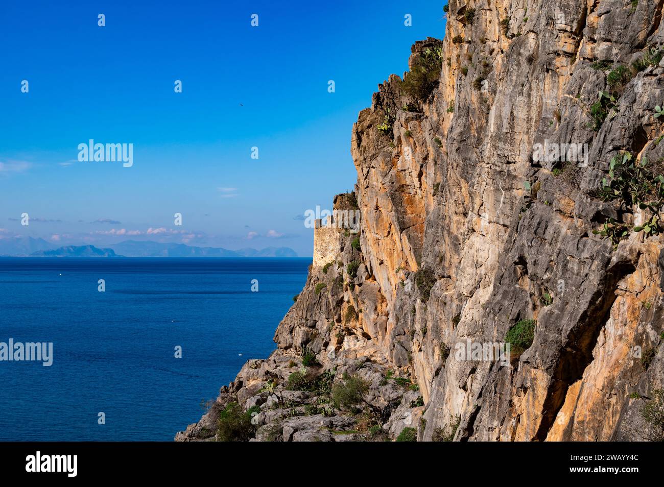 Rough texture of a rock with the blue sea and sky in the background ...