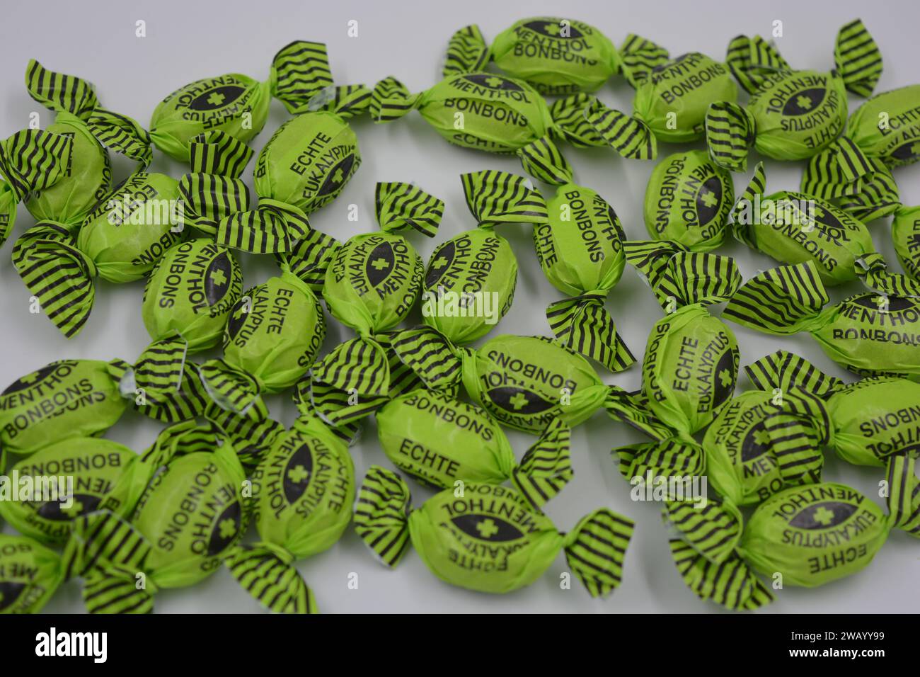 Bright, colorful factory menthol candies packed in green packaging with ...