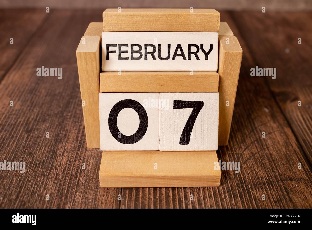 Cube shape calendar for February 07 on wooden surface with empty space ...