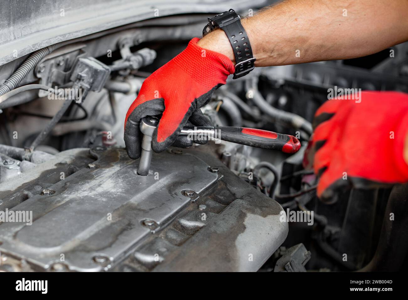 Car repairs. An auto mechanic unscrews the gas distribution mechanism ...