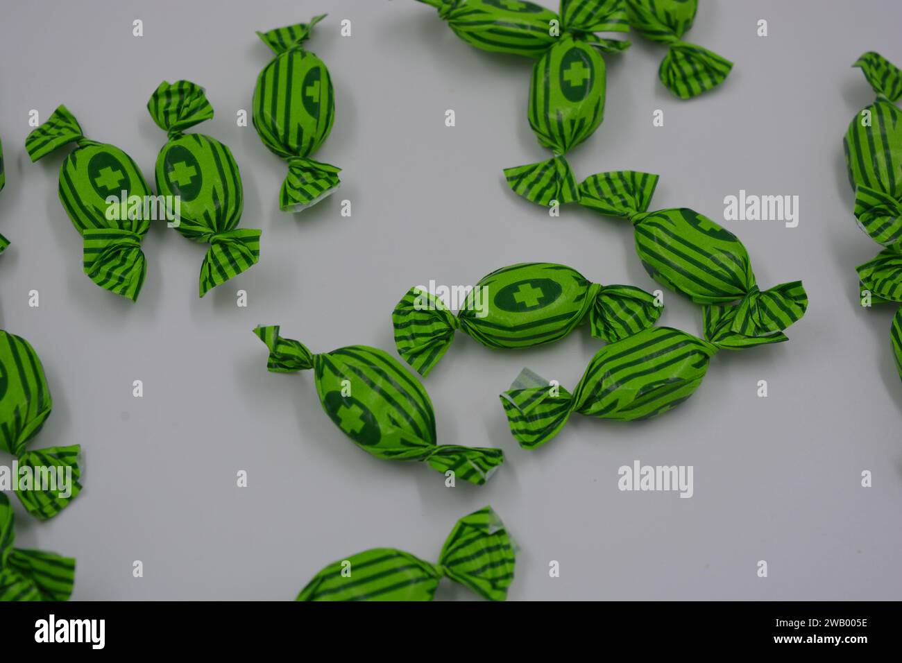 Bright, colorful factory menthol candies packed in green packaging with ...