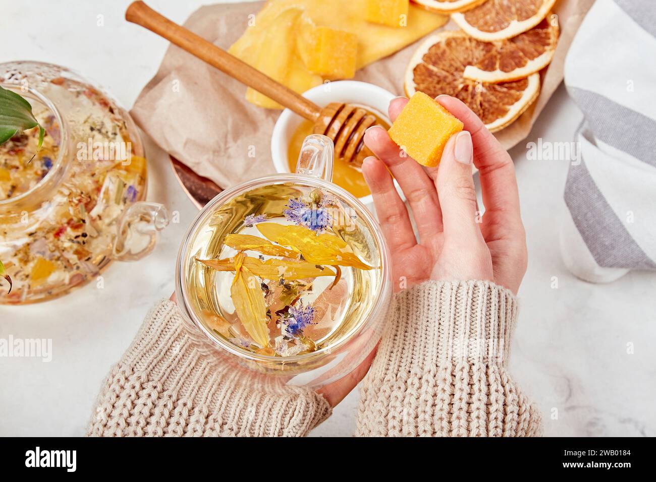 Woman add honey to organic mountain blend - calming herbal elixir ...