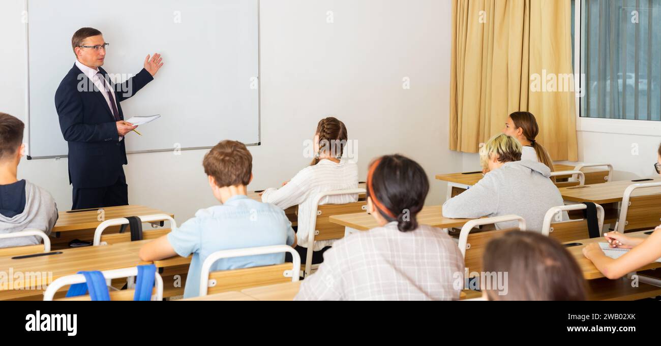 Male teacher lecturing to students at classroom Stock Photo - Alamy
