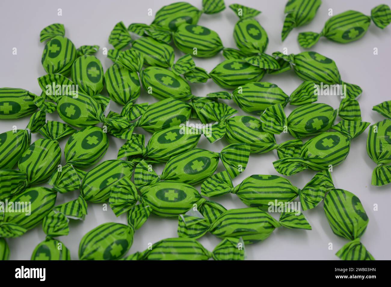 Bright, colorful factory menthol candies packed in green packaging with ...