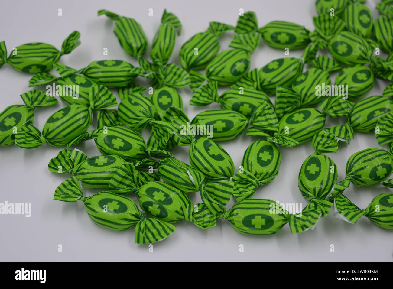 Bright, colorful factory menthol candies packed in green packaging with ...