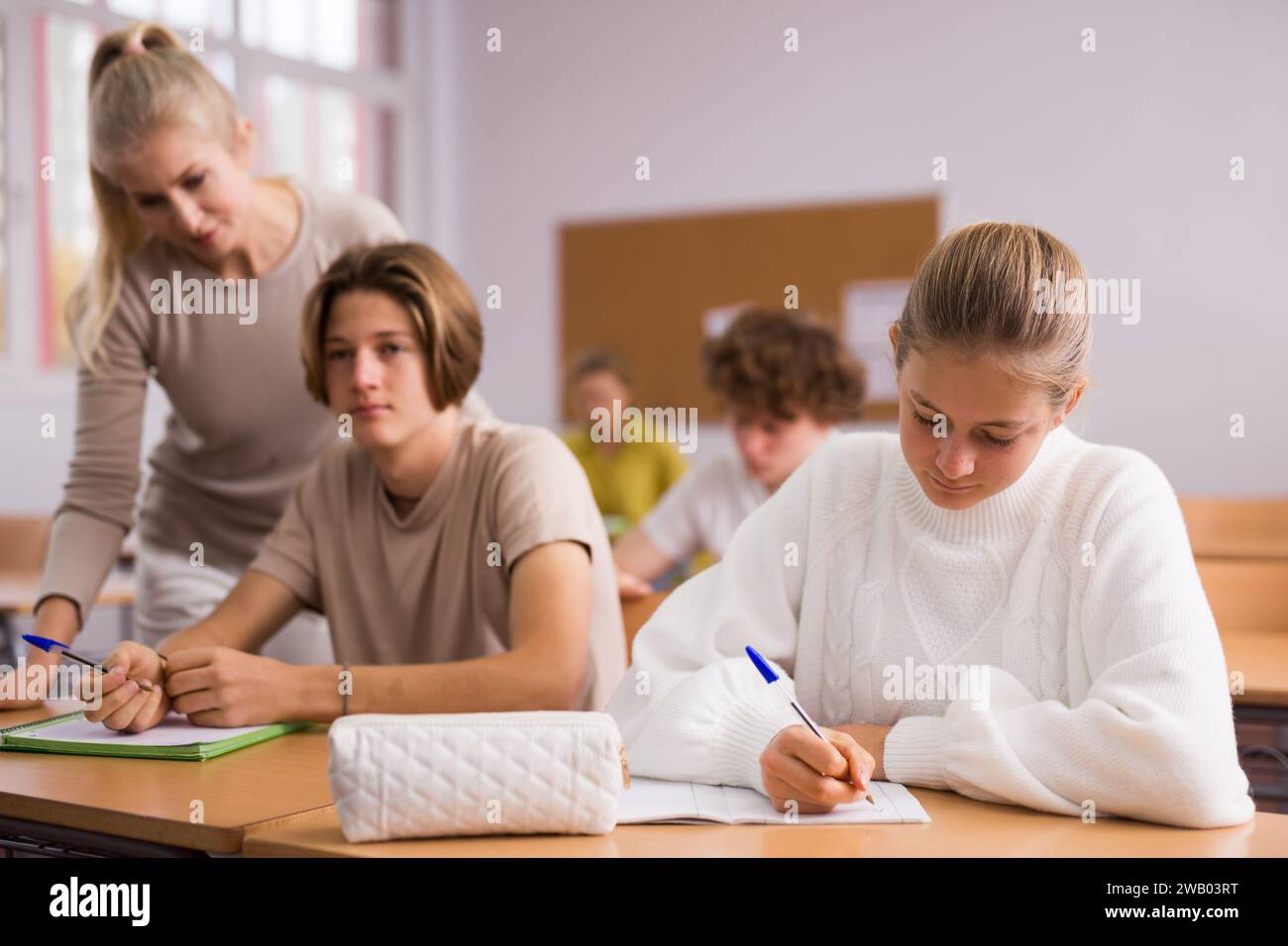 Group of school kids and teacher during lesson Stock Photo - Alamy