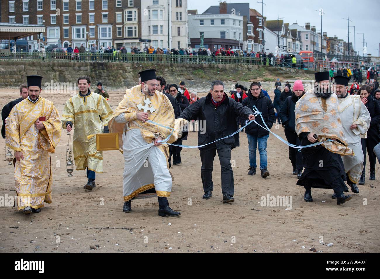 Priests walk along the beach to the sea blessing spot. Cyprian diaspora ...