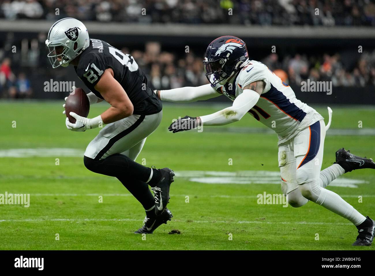 Las Vegas Raiders tight end Austin Hooper, left, makes a catch in front ...