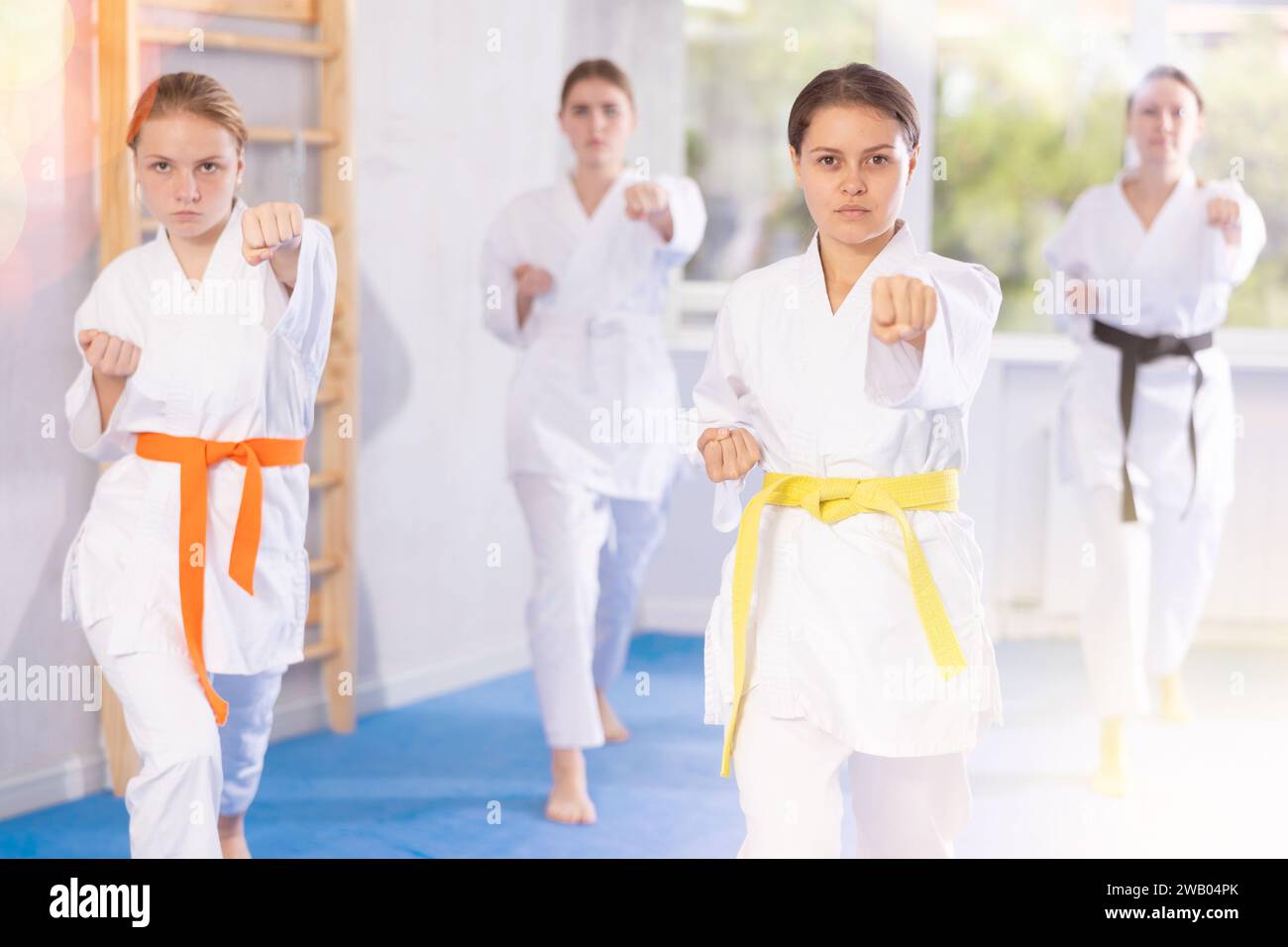 Team of teenage girls in kimonos stand in fighting stance during group ...