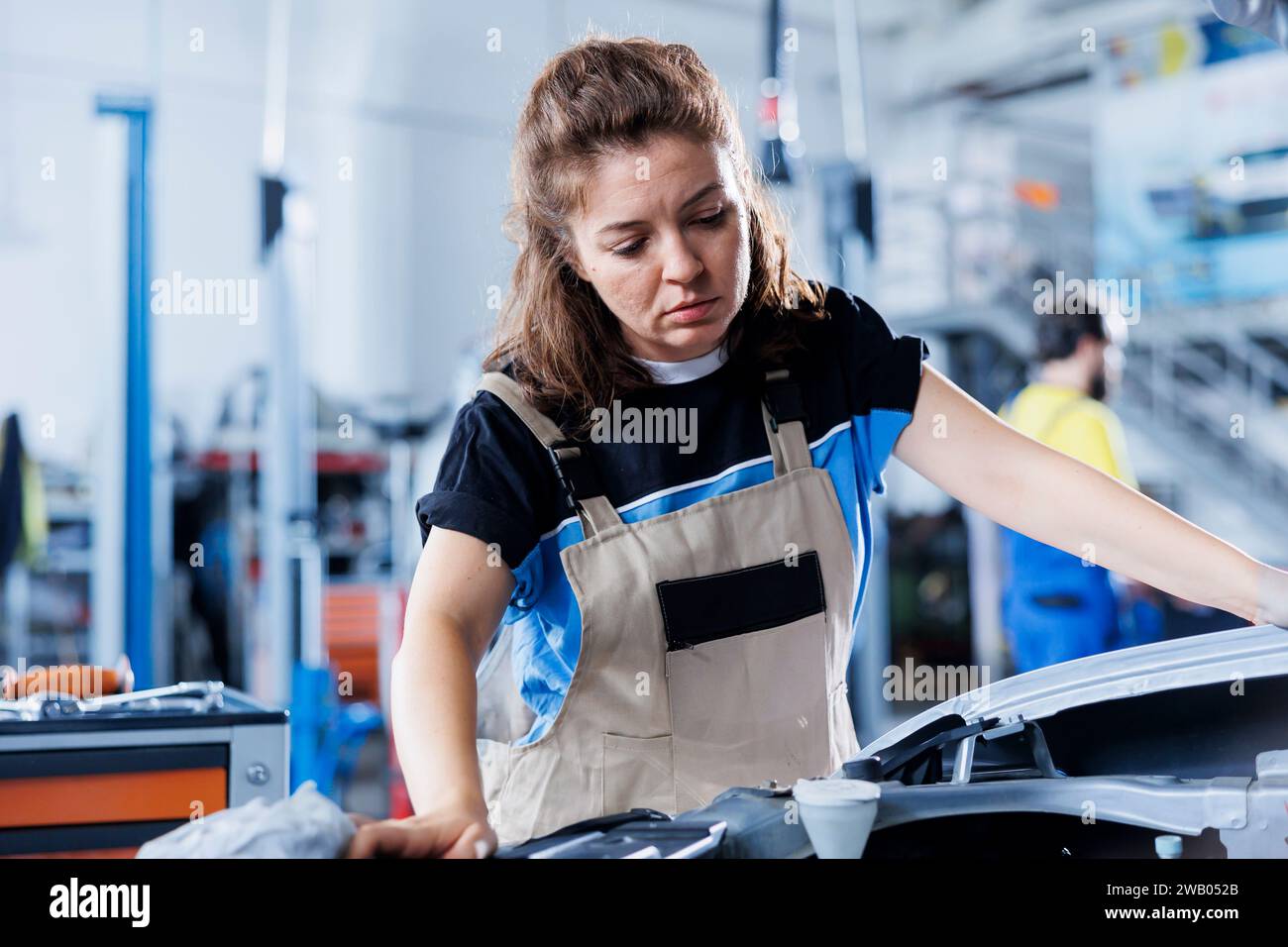 Repair shop technician examines faulty car battery using advanced ...