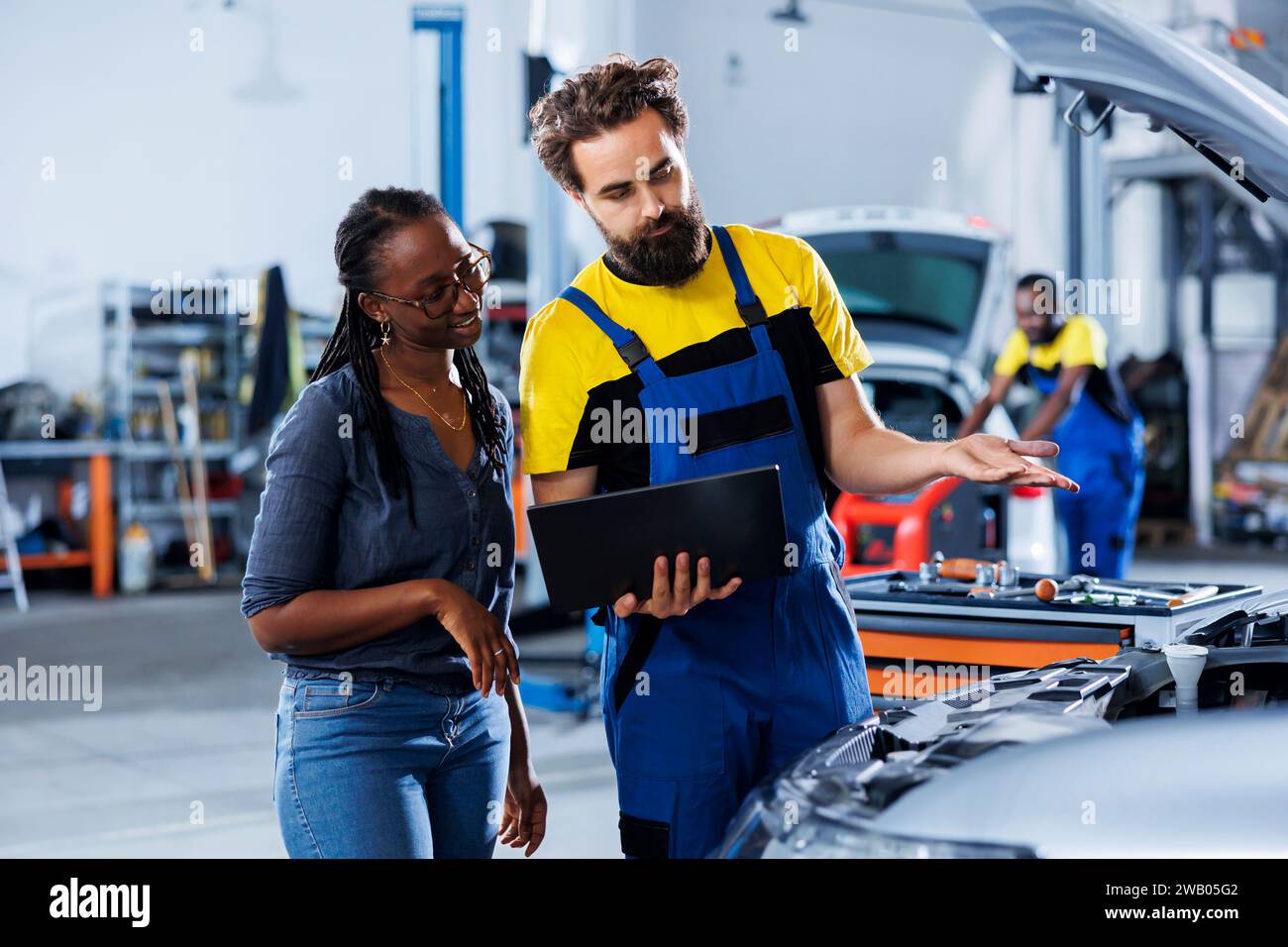Mechanic at auto repair shop conducts annual vehicle checkup, informing ...