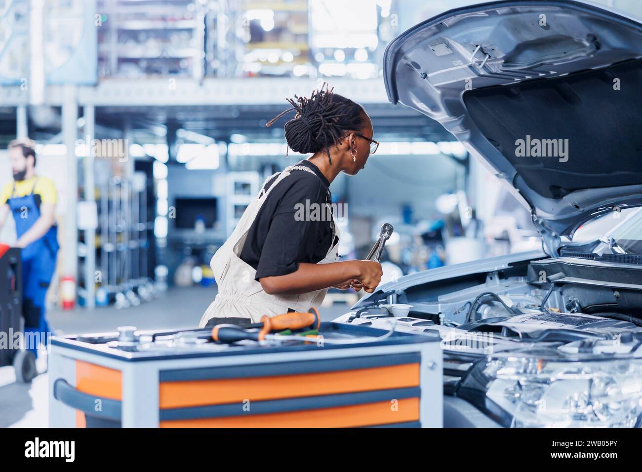 Car service serviceman expertly examines engine using advanced mechanical tools, ensuring ...