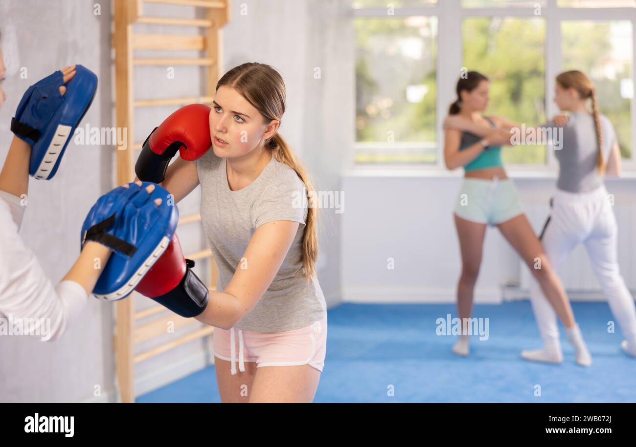 Boxing training - teen girl wearing boxing gloves exercise and punch to ...