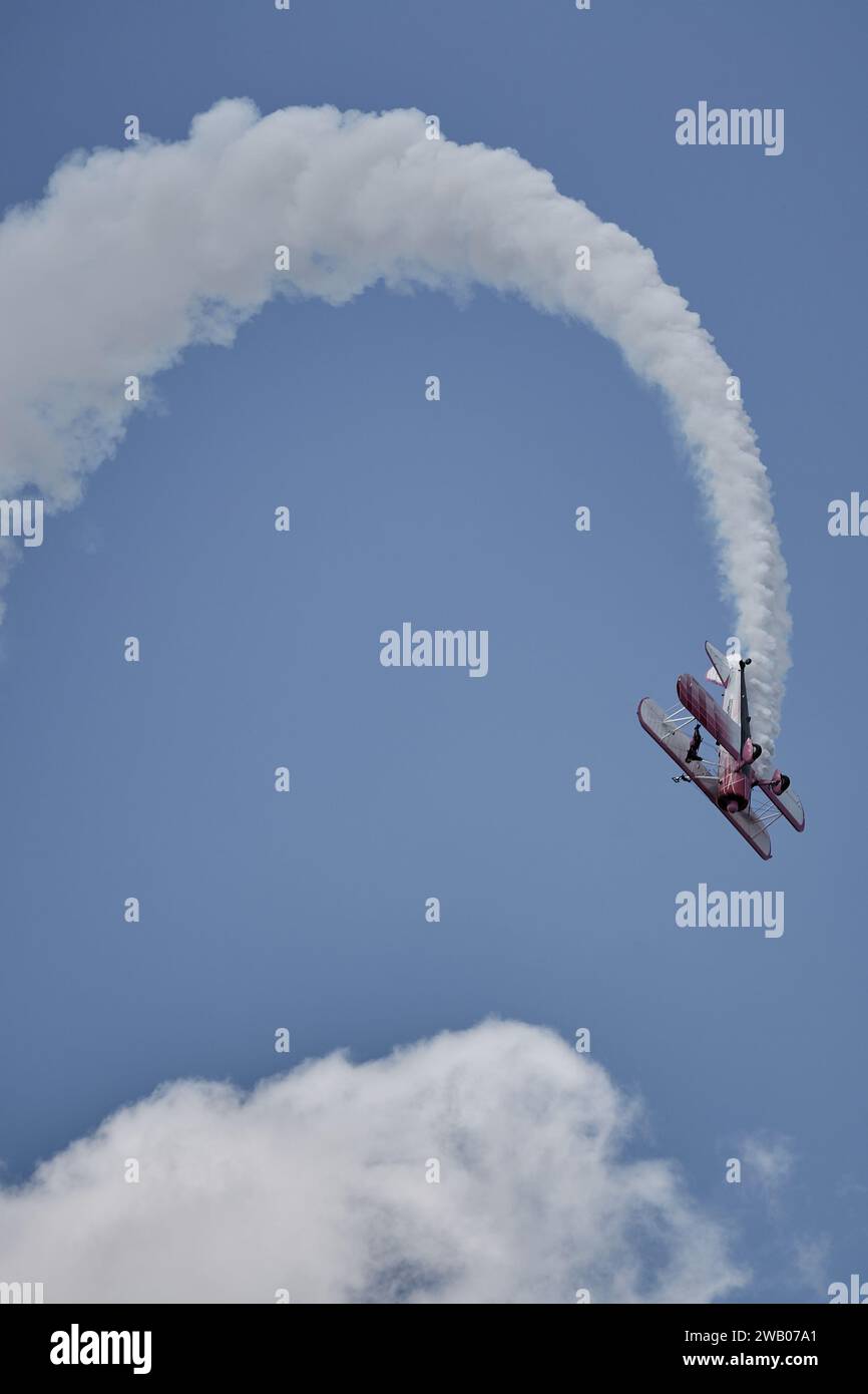 Aerobatic looping with pink biplane and stunt with a big tail smoke ...