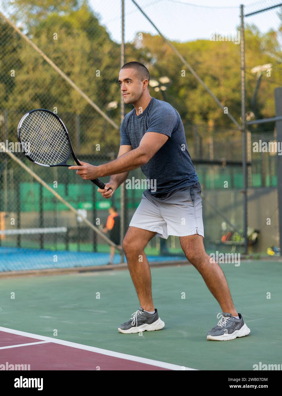 Man playing doubles tennis with female partners at warm sunny day ...