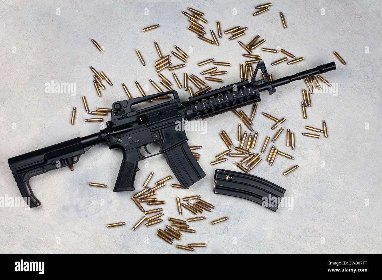 M4 carbine and 5.56mm shells and magazine with bullets on grey concrete ...
