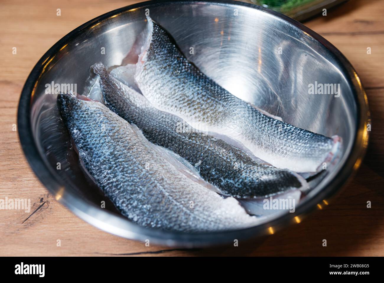 three silver-skinned sea bass fish fillets, scaled Stock Photo - Alamy