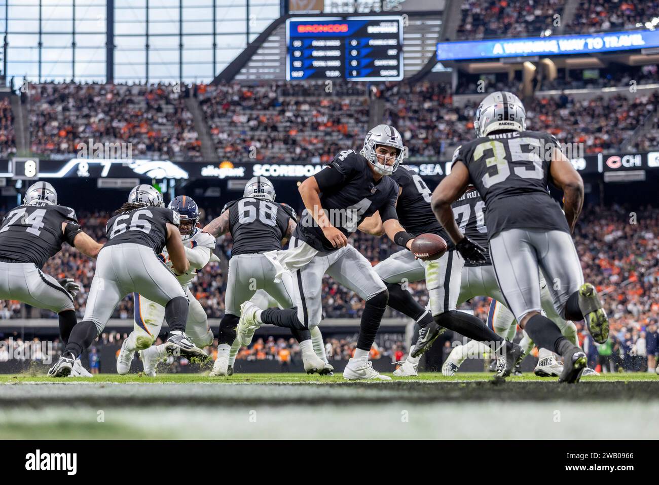 Las Vegas Raiders quarterback Aiden O'Connell (4) hands the ball off to ...