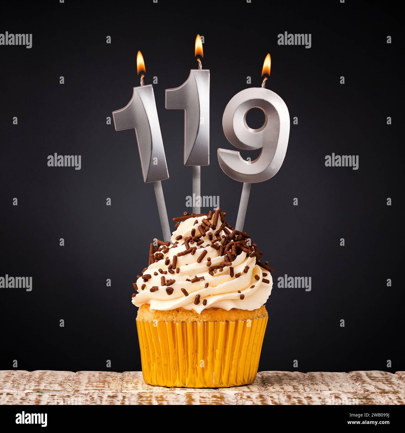 Birthday candle number 119 - Anniversary cupcake on black background ...
