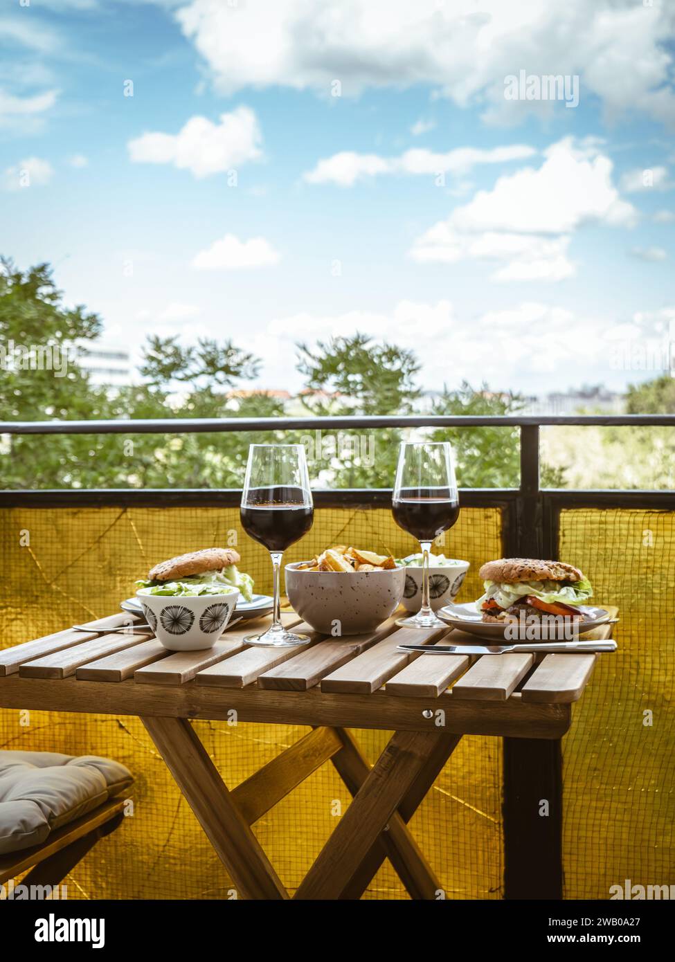 Table for a home dinner lunch date on a balcony with burgers fries ...