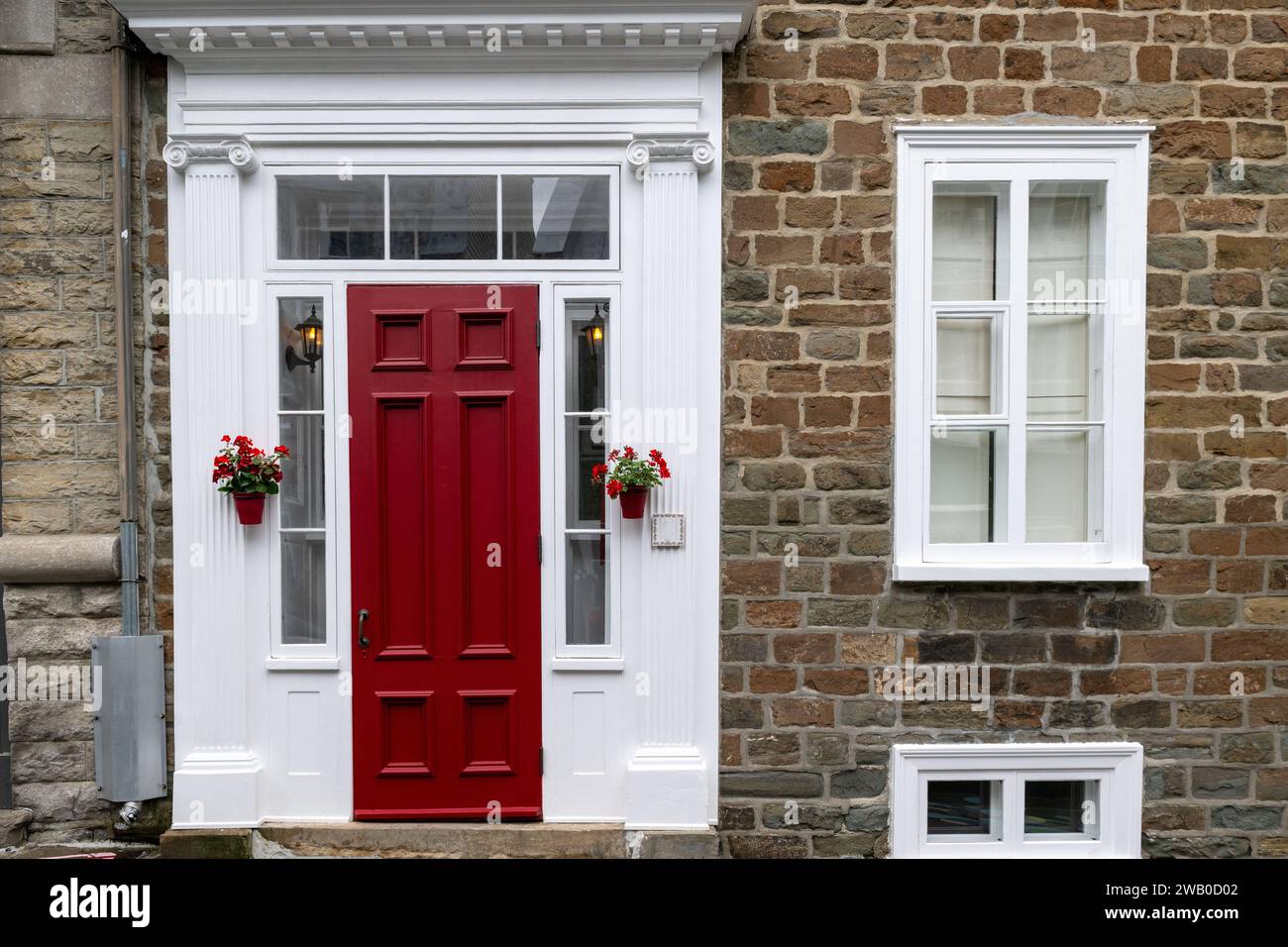 A vibrant red solid front door to a house. The exterior wall is brown ...