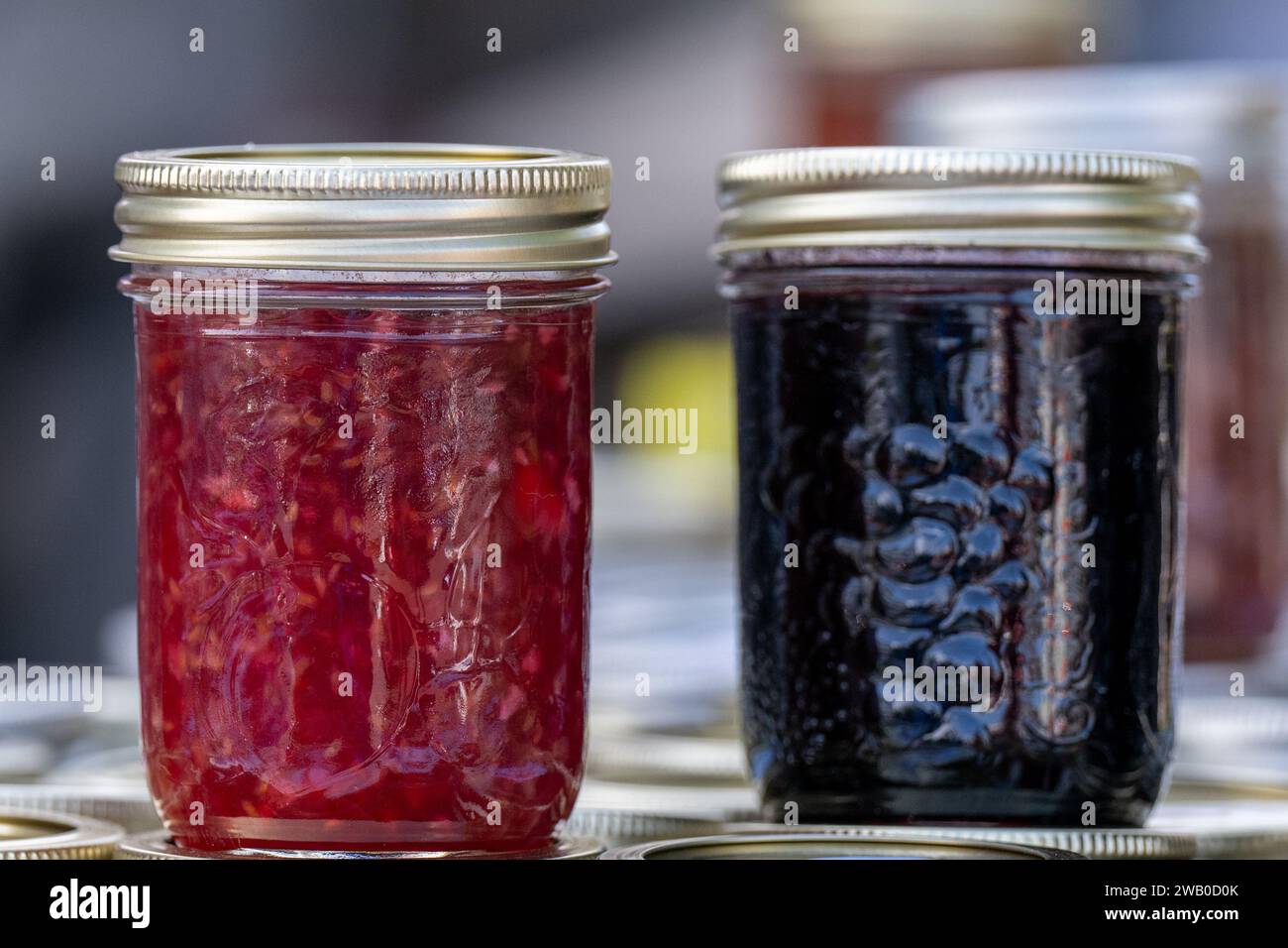 Two small glass jars of various homemade strawberry, raspberry, and ...