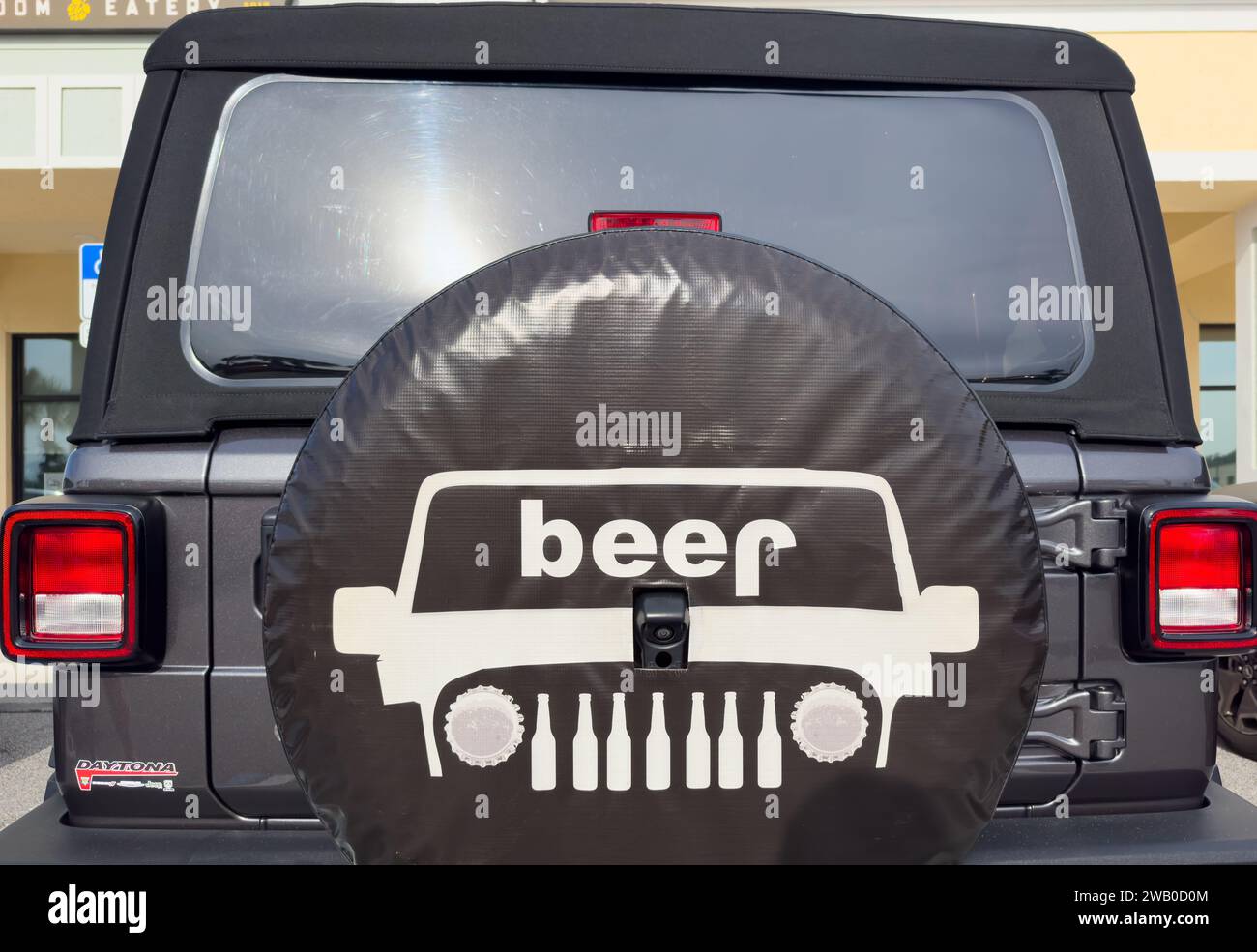 The rear of a grey-colored Jeep Wrangler 4x4, with a soft top, sport ...