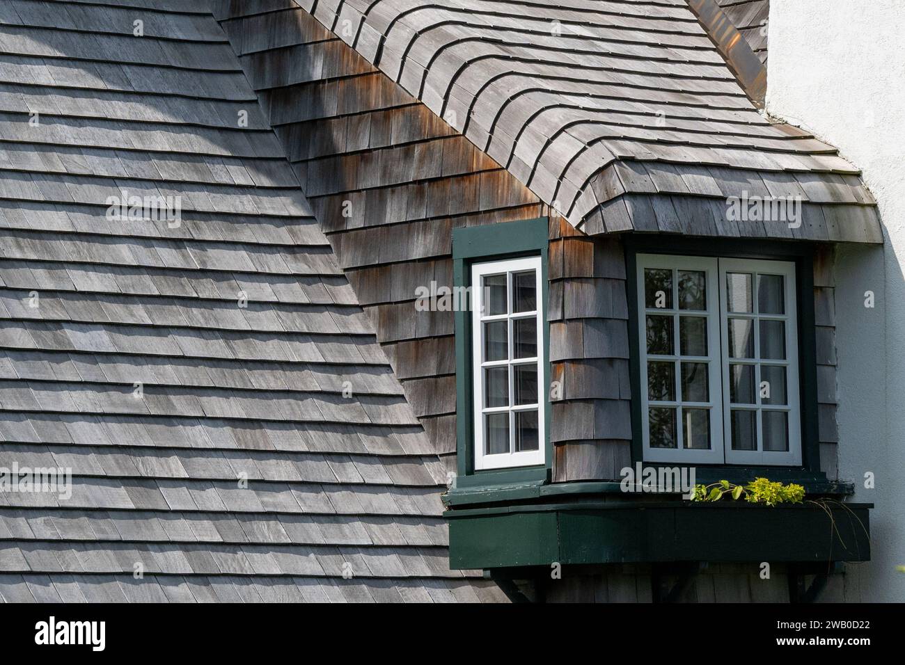A steep roof of a vintage building with cedar wood shingles. There's a ...