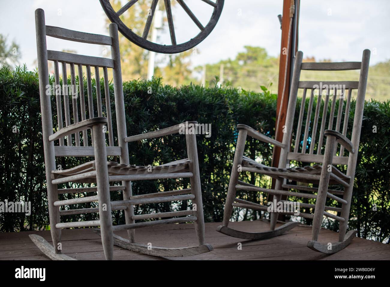 Two rustic wooden rocking chairs, weathered and worn, on the front ...