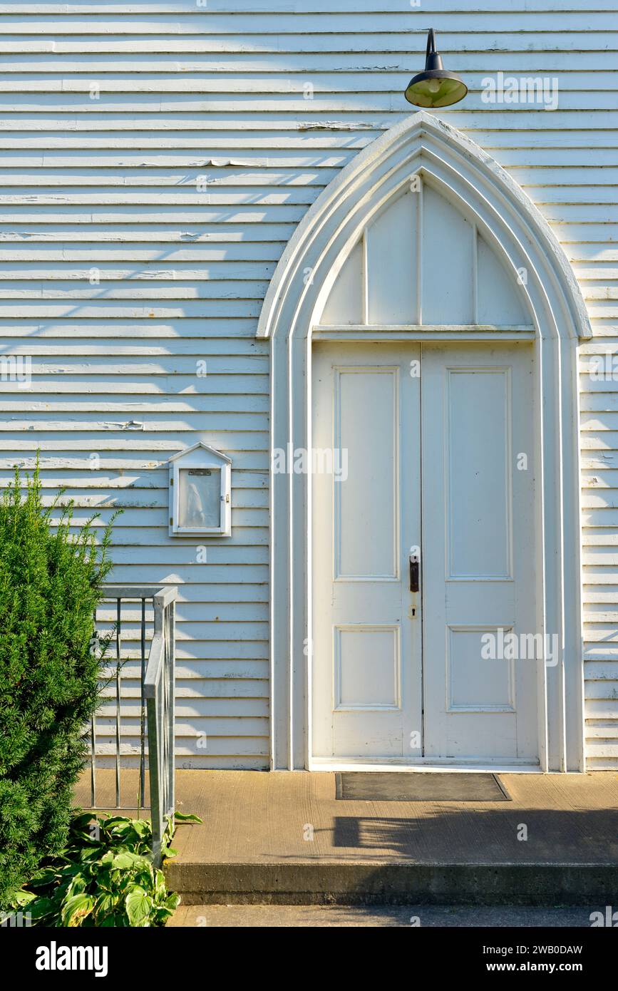 Steps lead to the entrance of a white wooden religious building with ...