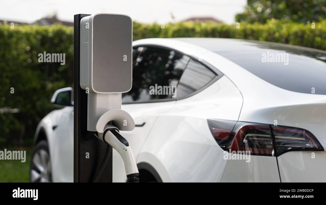 Closeup EV charger plug handle attached to electric vehicle port ...