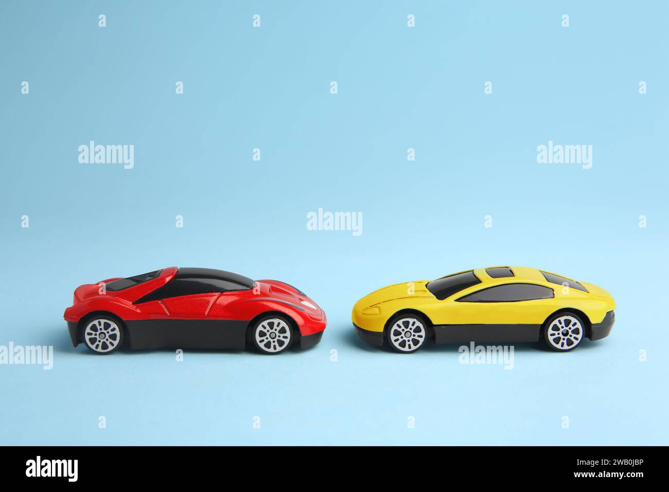 Two bright cars on light blue background. Children`s toys Stock Photo ...